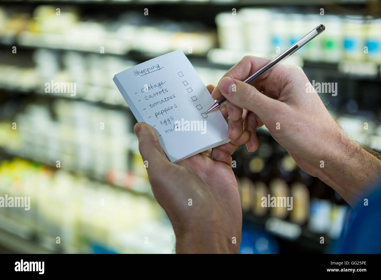 Man ticking on shopping checklist Stock Photo - Alamy