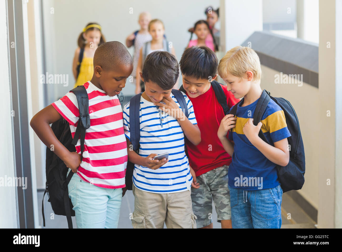 School kids using mobile phone in corridor Stock Photo - Alamy