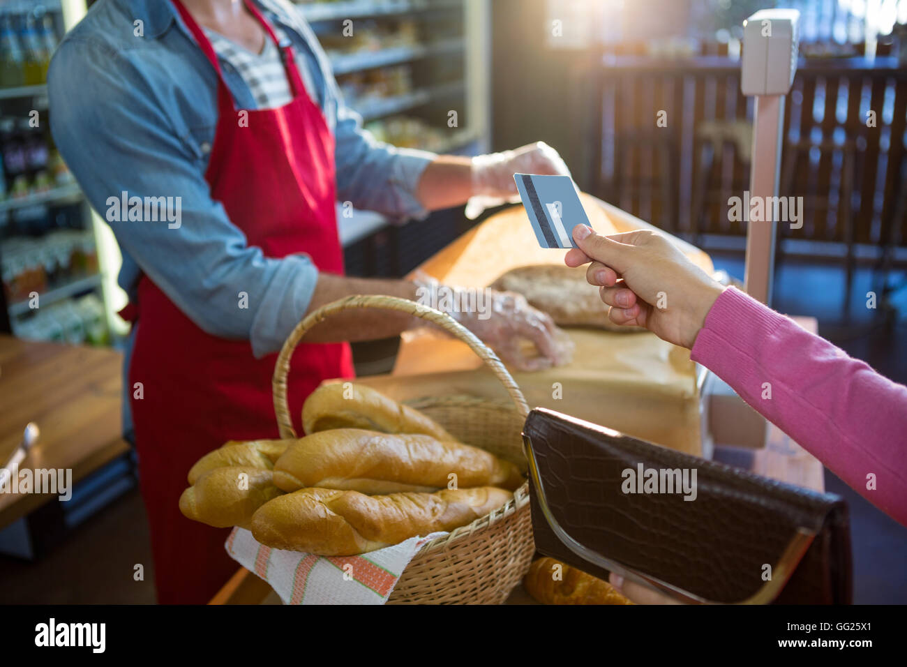Hand giving credit card at payment counter Stock Photo - Alamy