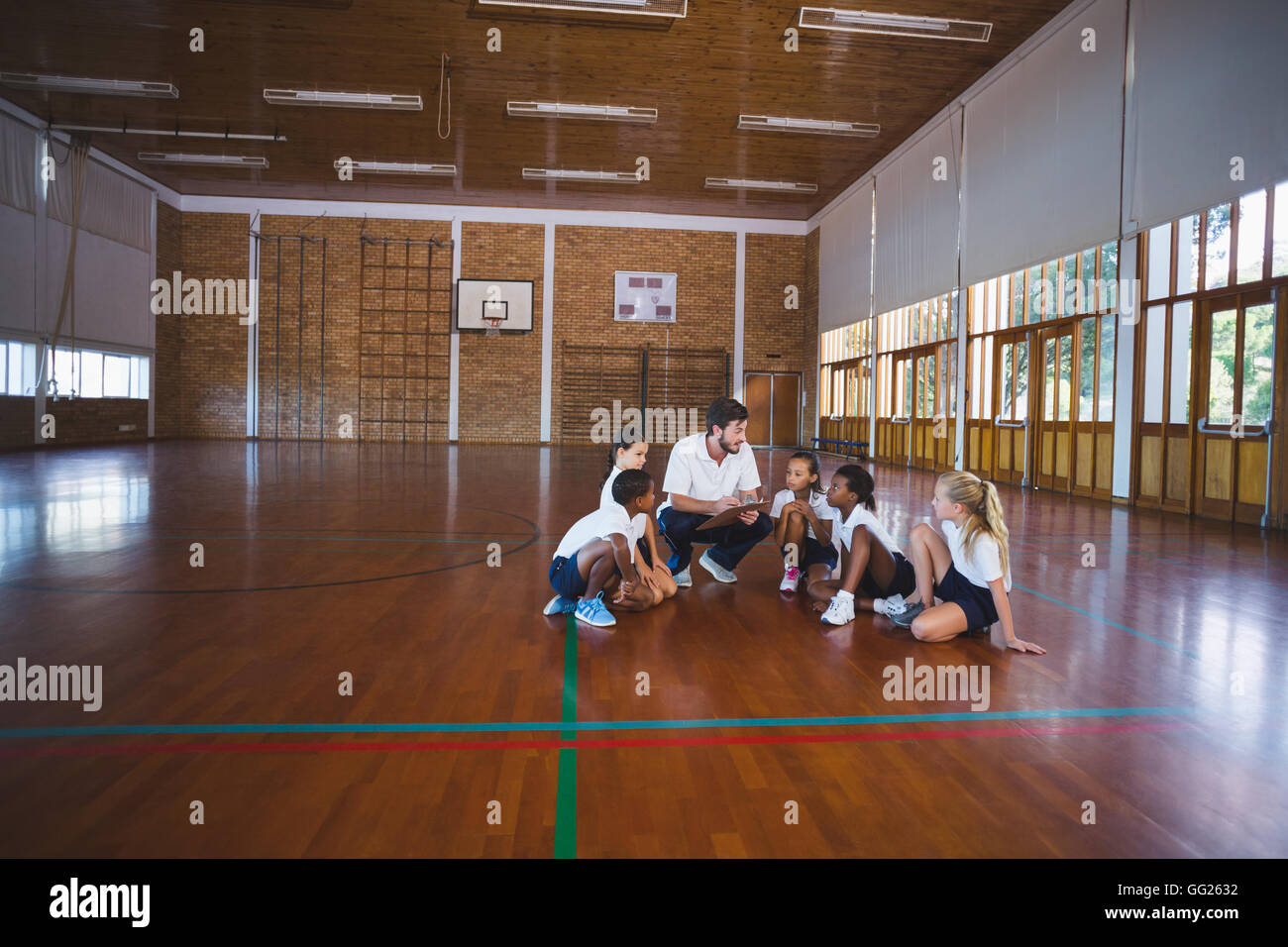 Sports teacher having discussion with his students Stock Photo - Alamy