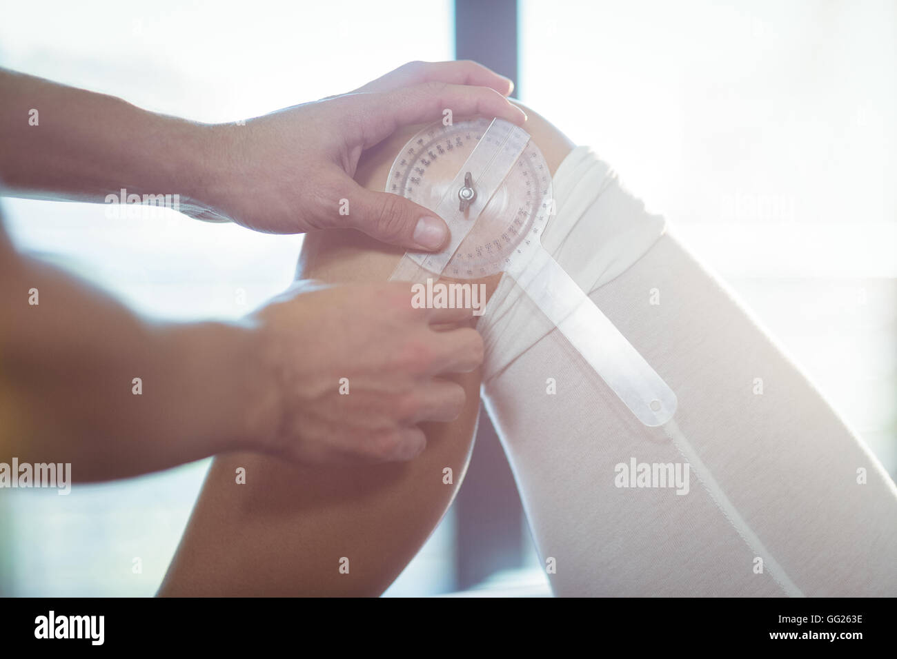 Male therapist measuring female patient knee with medical ruler Stock ...