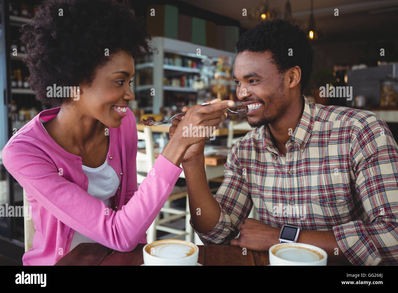 Young couple feeding each other Stock Photo - Alamy