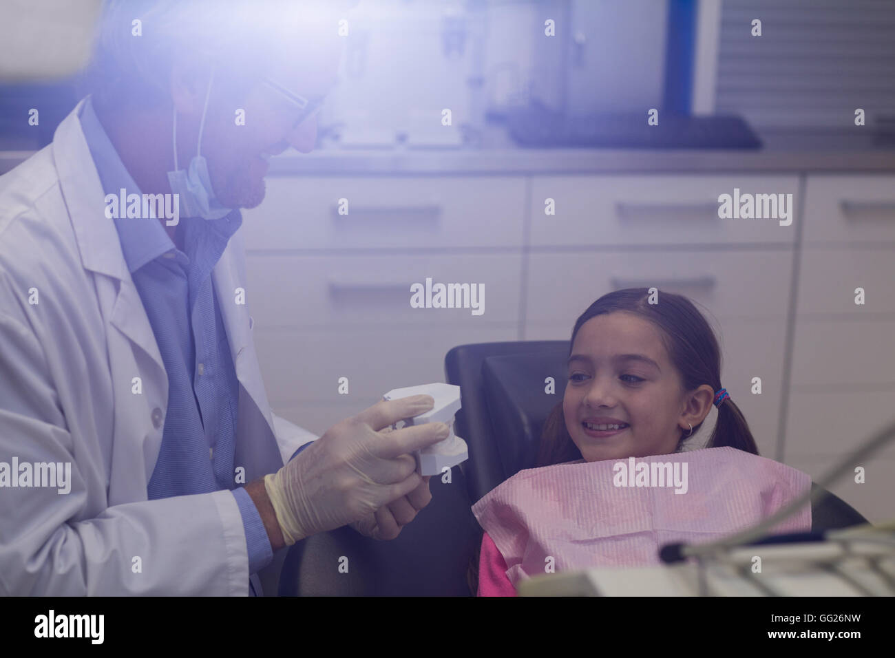 Dentist showing model teeth to patient Stock Photo - Alamy