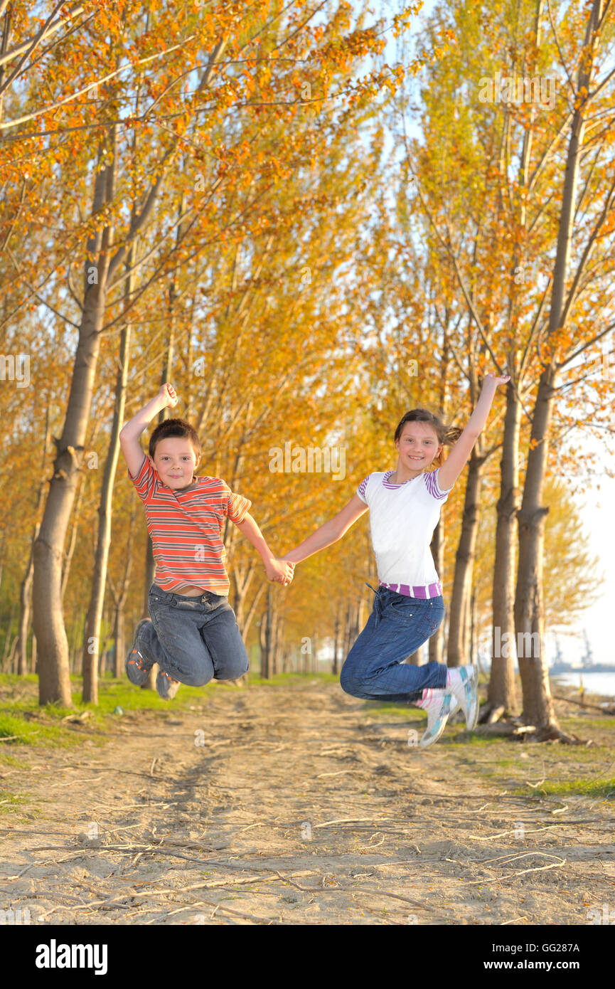 Happy active children jumping in forest Stock Photo - Alamy