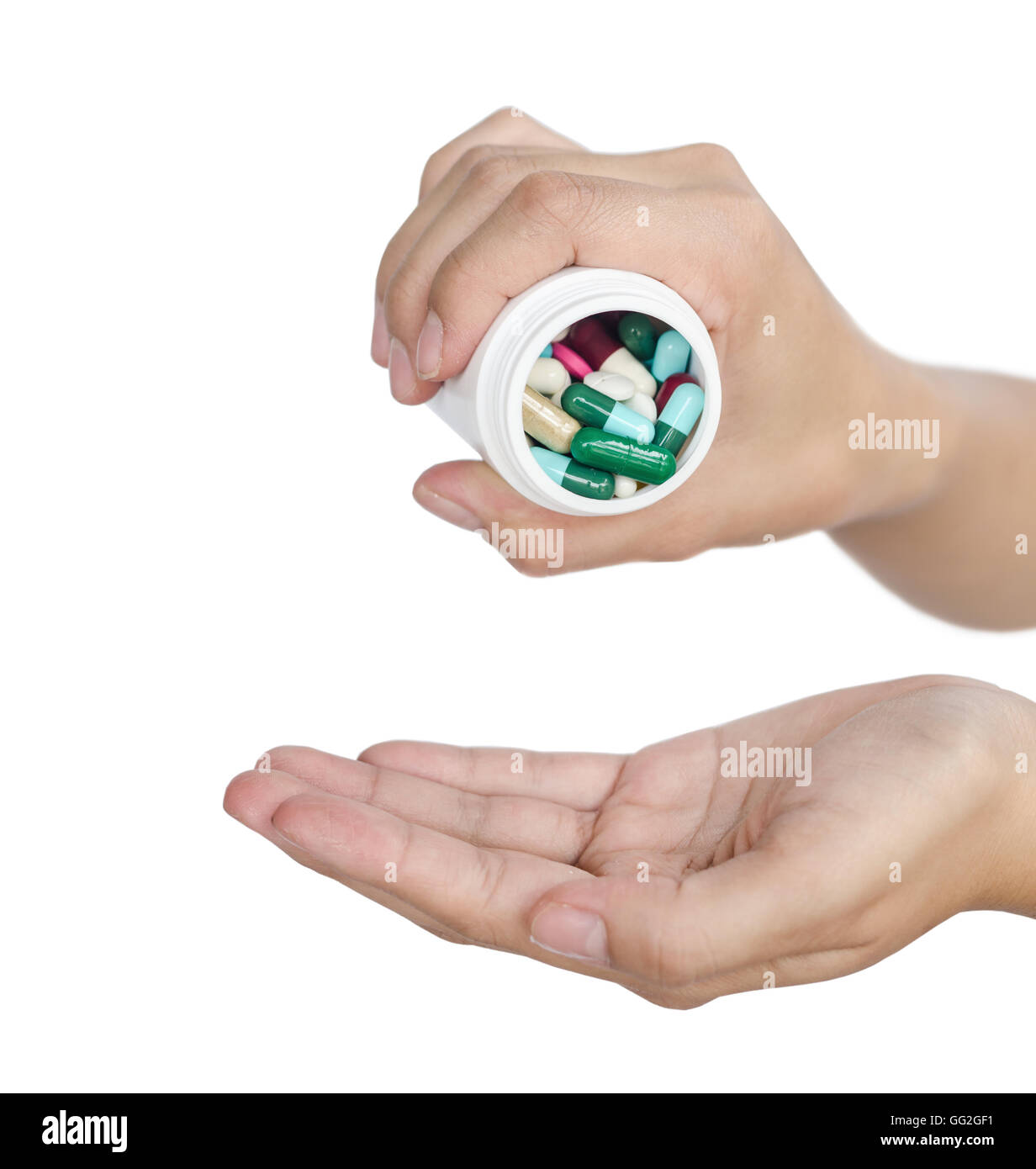 Hand of a woman holding a pill against white background Stock Photo - Alamy