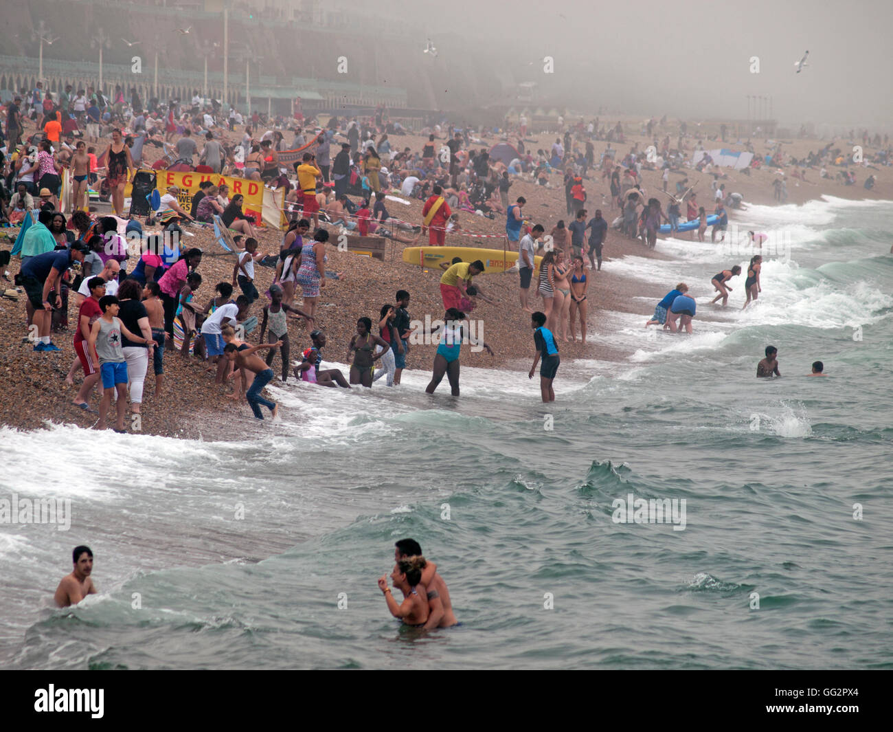 Lots of people having fun in the sea and on the beach in Brighton Stock ...