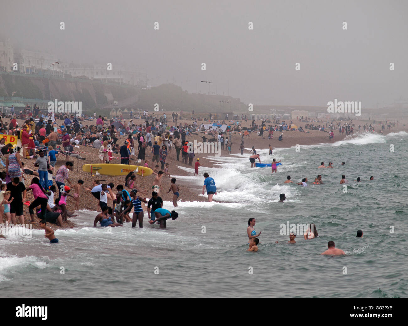 Lots of people having fun in the sea and on the beach in Brighton Stock ...