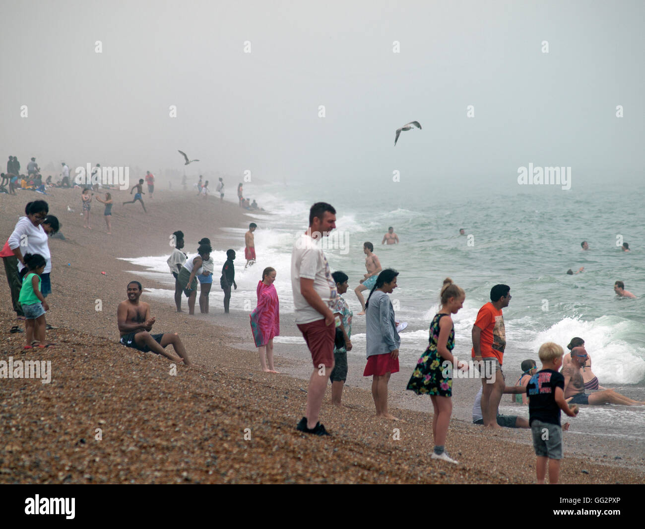 Lots of people having fun in the sea and on the beach in Brighton Stock ...