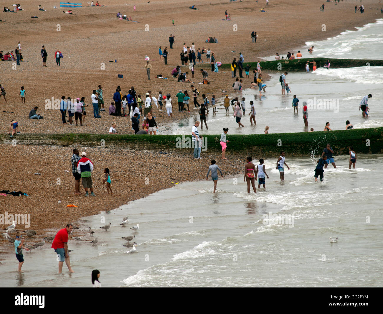Lots of people having fun in the sea and on the beach in Brighton Stock ...