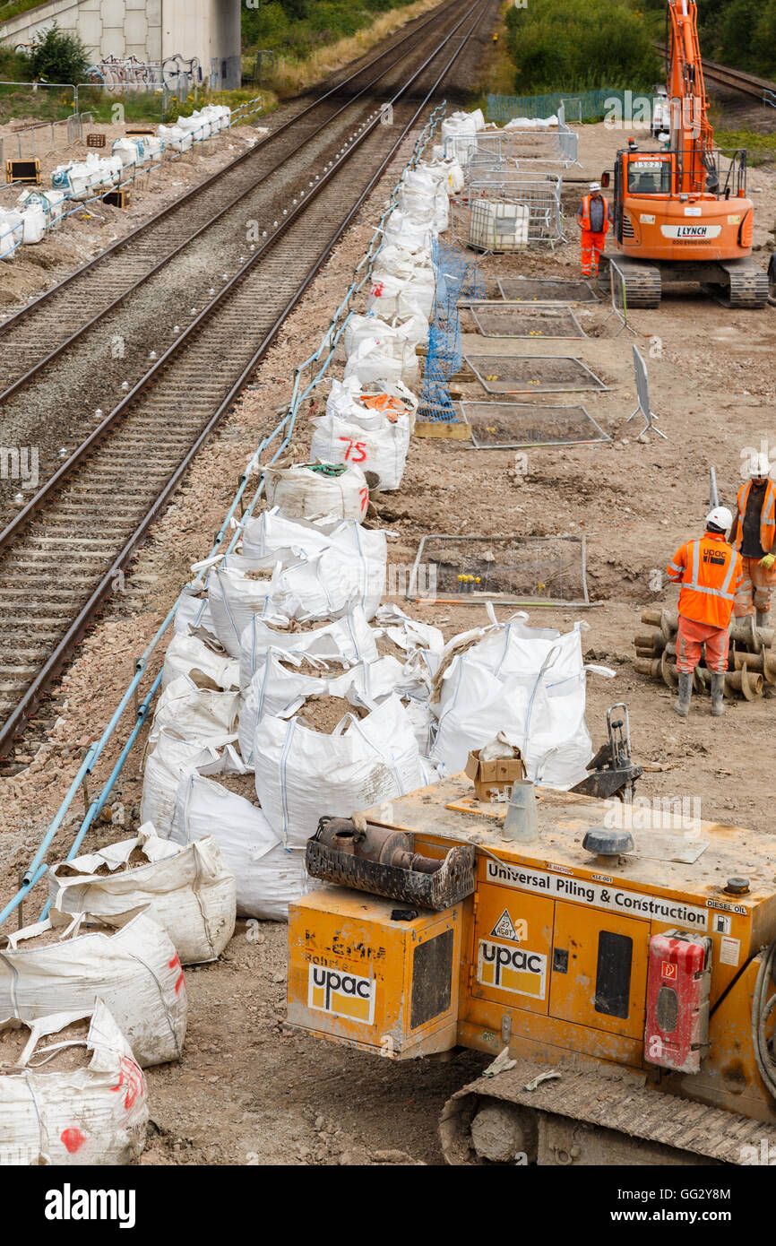 Construction workers on site next to a section of railway track. In ...