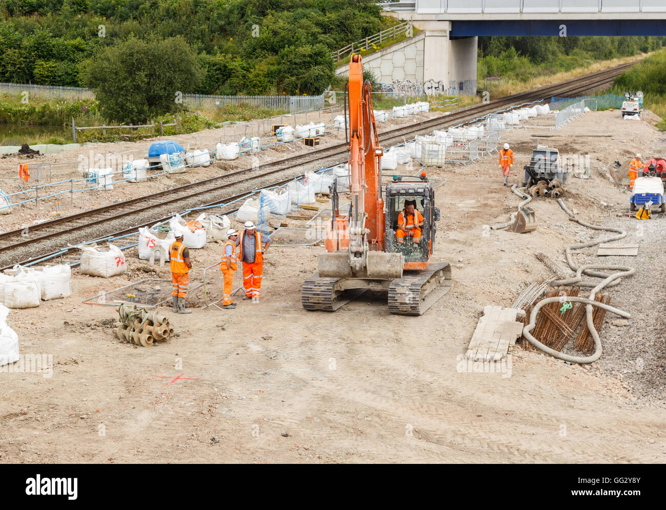 Construction workers on site next to a section of railway track. In ...