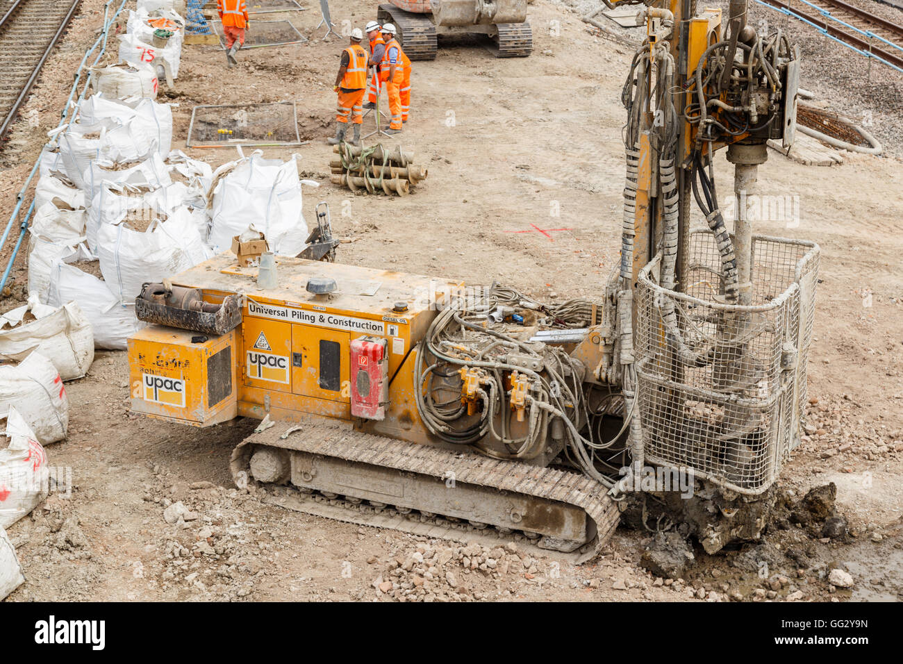Construction workers, and pile drilling machine, on site next to a ...