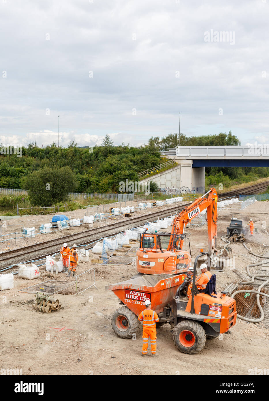 Construction workers on site next to a section of railway track. In ...