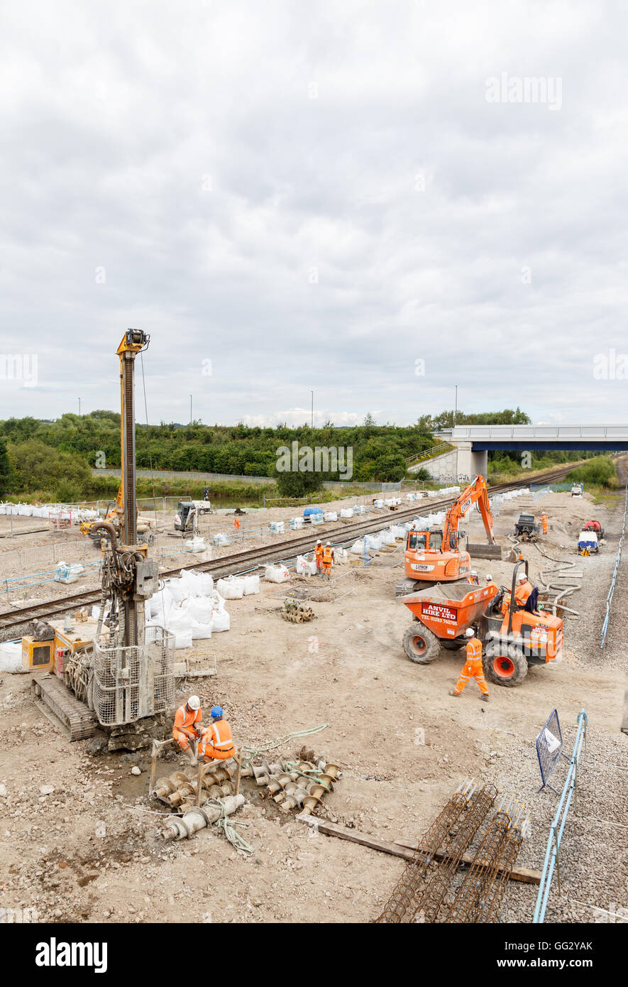 Construction workers on site next to a section of railway track. In ...