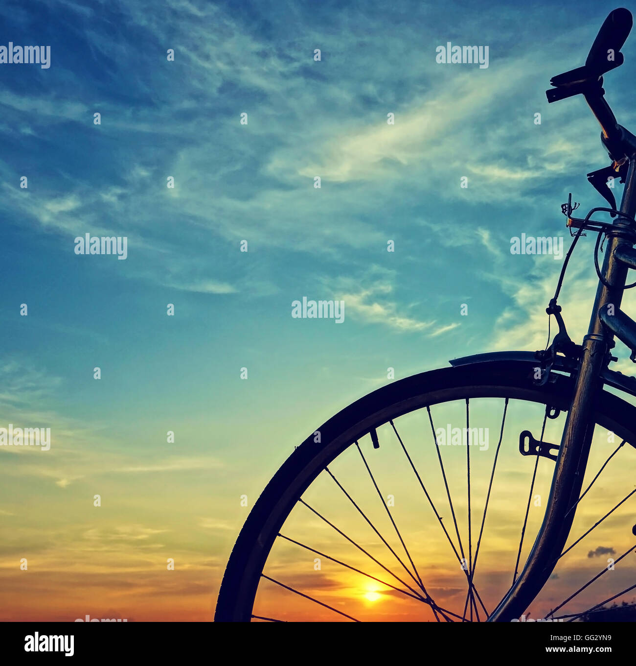 Beautiful bicycle at sunset, sun on blue sky in vintage colors ...