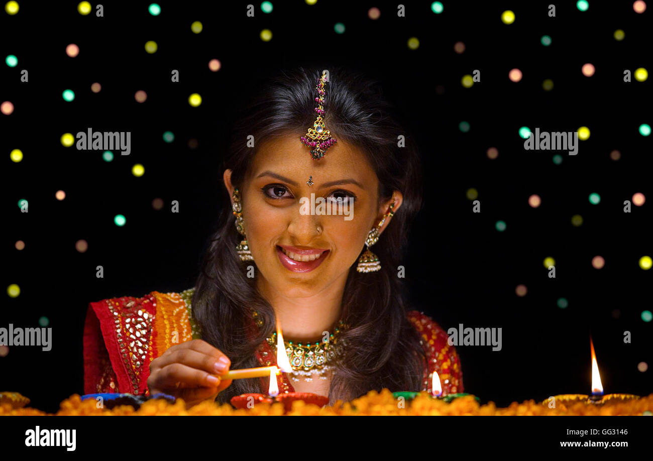 Traditional indian woman lighting diya hi-res stock photography and ...