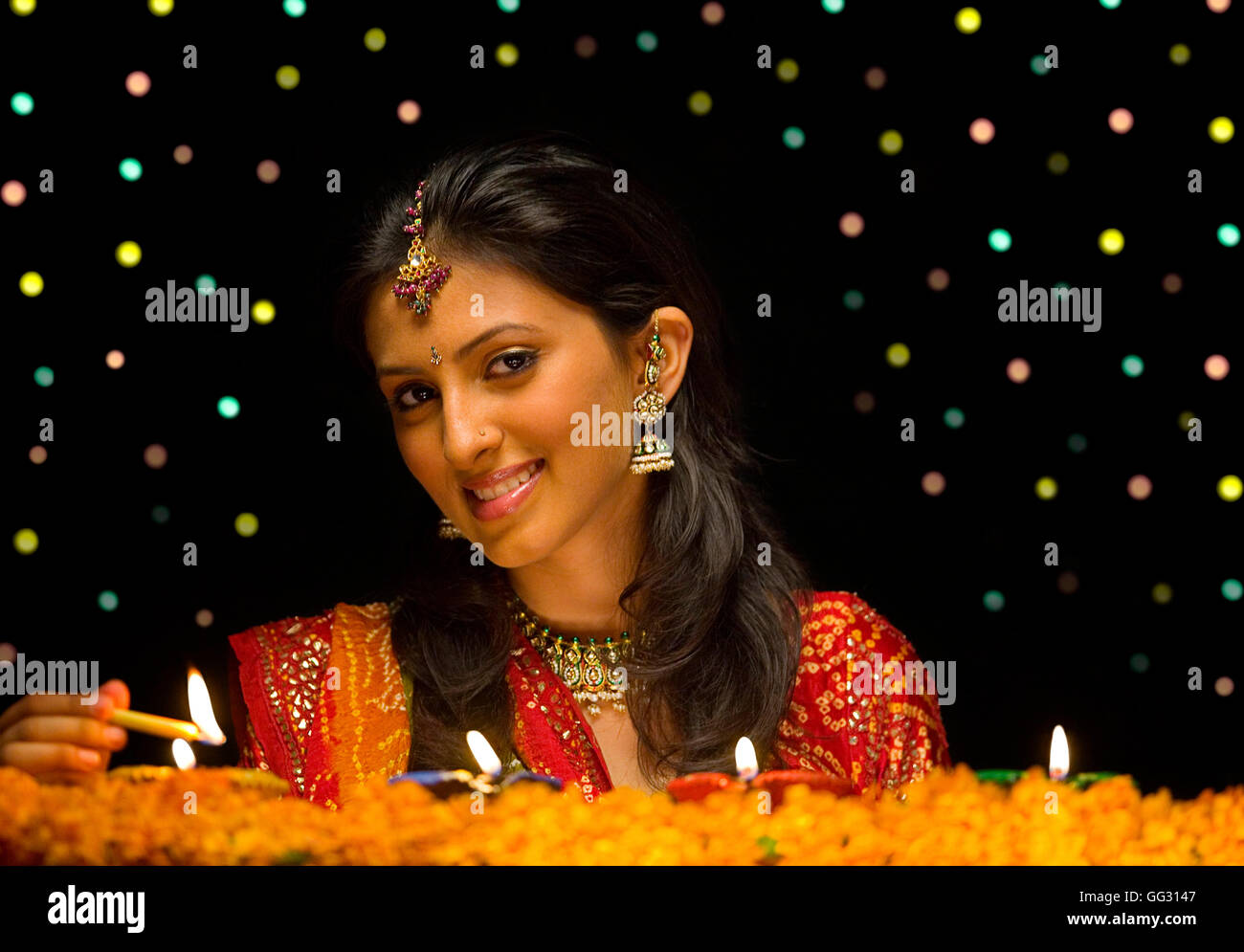 Traditional indian woman lighting diya hi-res stock photography and ...