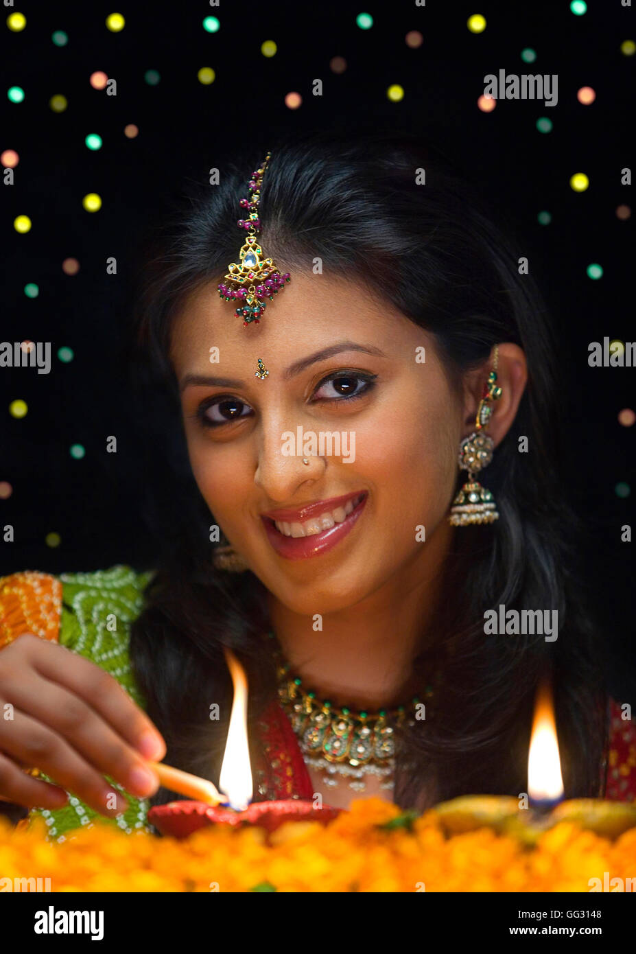 Traditional indian woman lighting diya hi-res stock photography and ...