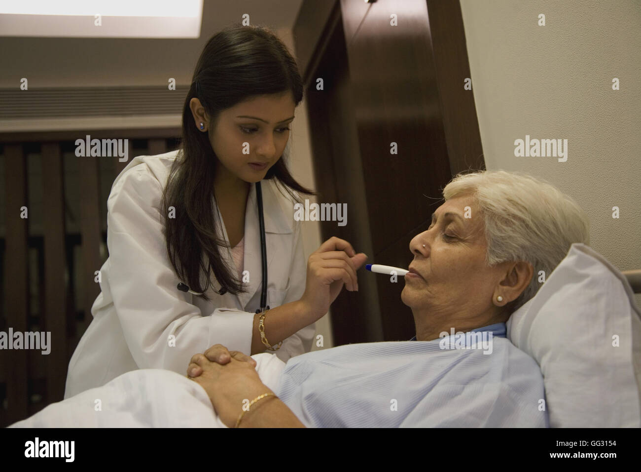 Doctor taking patient's temperature Stock Photo - Alamy