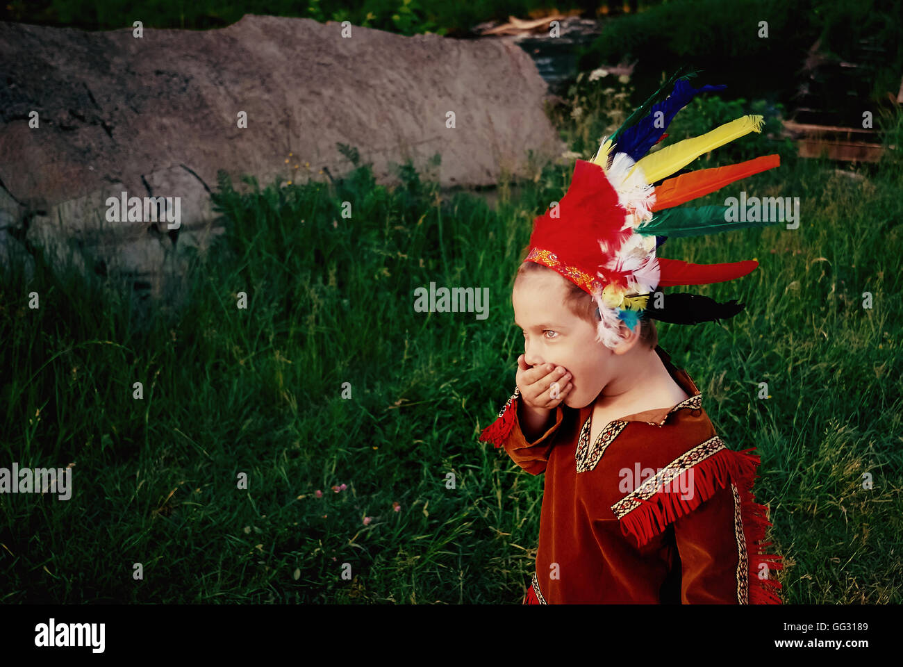 a little boy in a red suit Indian shouts pressing his hand to face, on ...