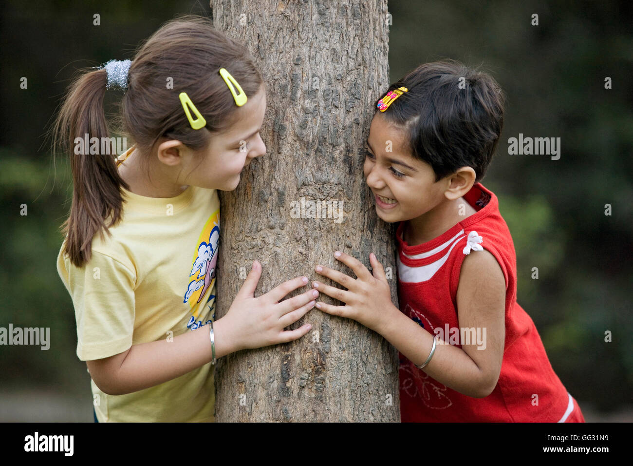 Girls hugging a tree Stock Photo - Alamy