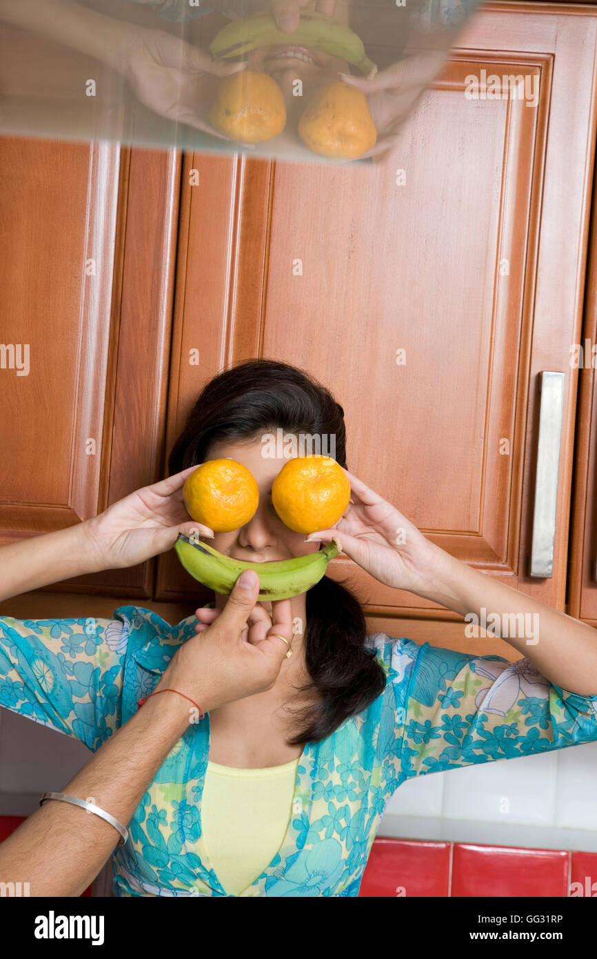 Woman covering her face with fruits Stock Photo - Alamy