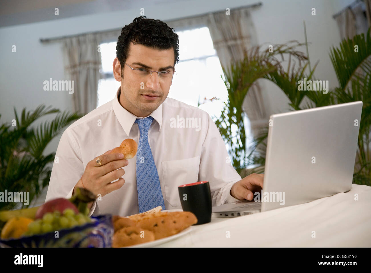 Man eating and working Stock Photo - Alamy