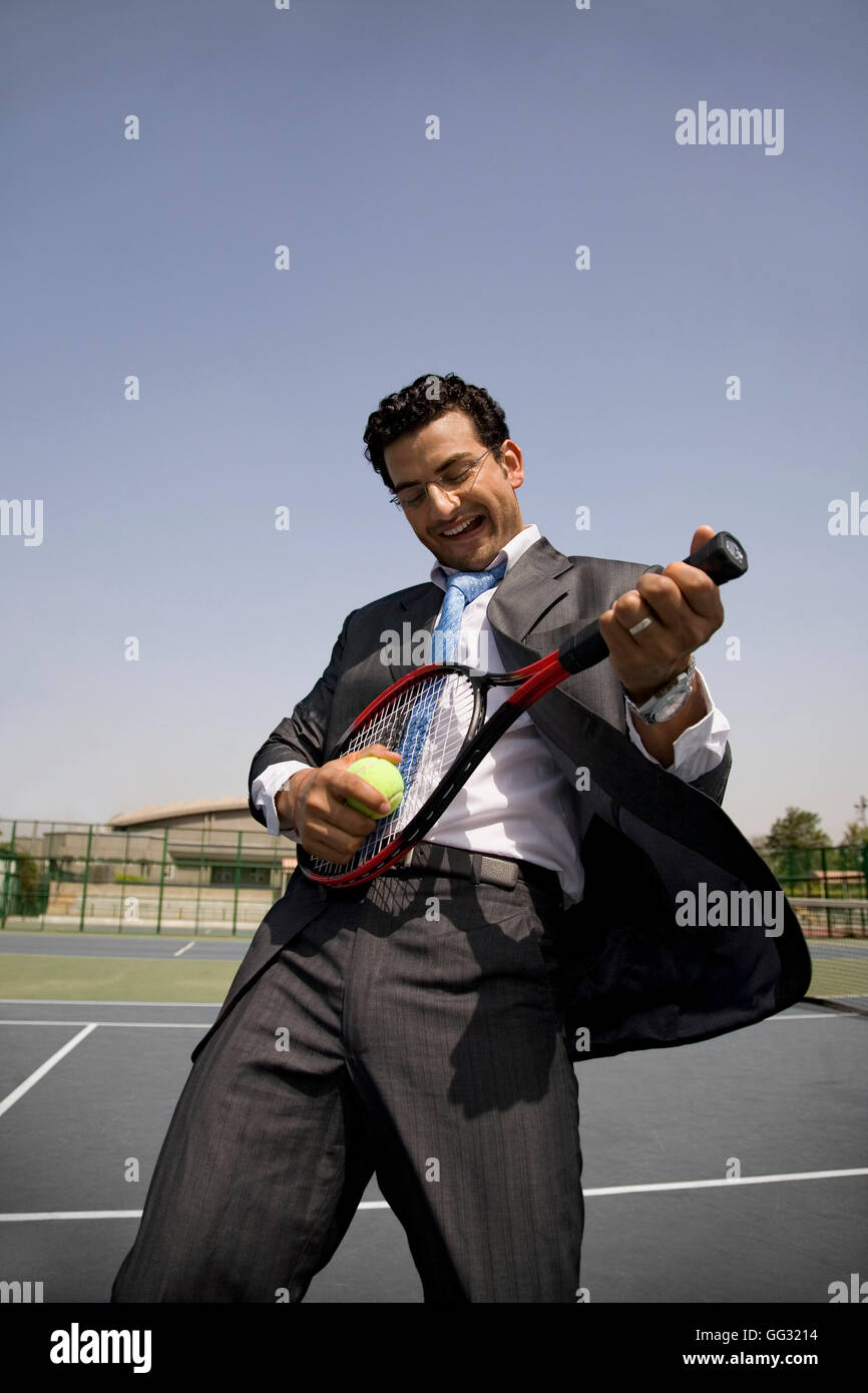 Executive holding a racket and a ball Stock Photo - Alamy