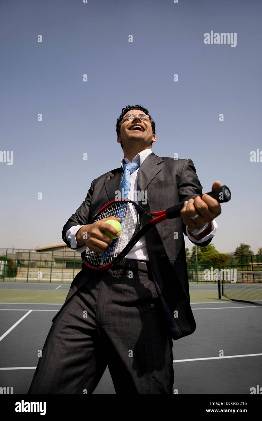 Executive holding a racket and a ball Stock Photo - Alamy