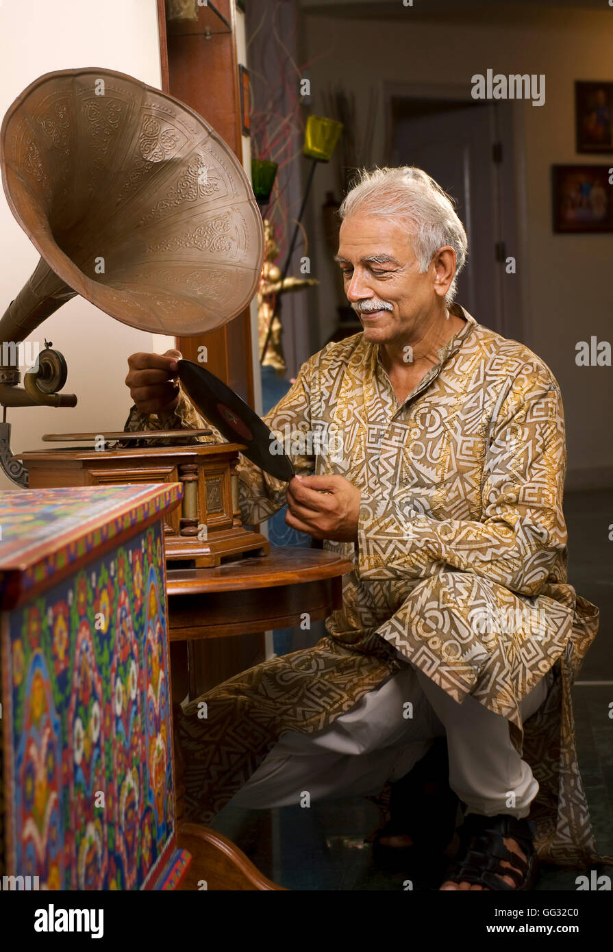 Old man looking at a record Stock Photo - Alamy
