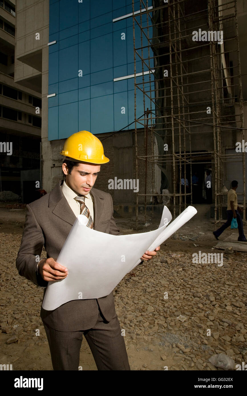 Engineer looking at blueprints Stock Photo - Alamy