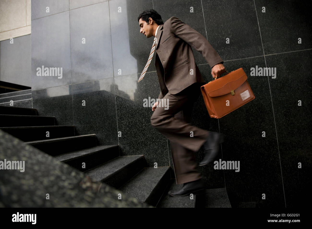 Executive running up the stairs Stock Photo - Alamy