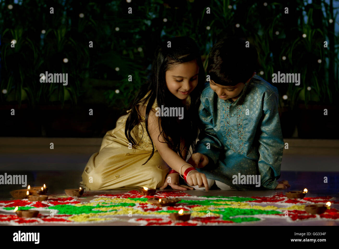 Boy and girl making a rangoli Stock Photo - Alamy