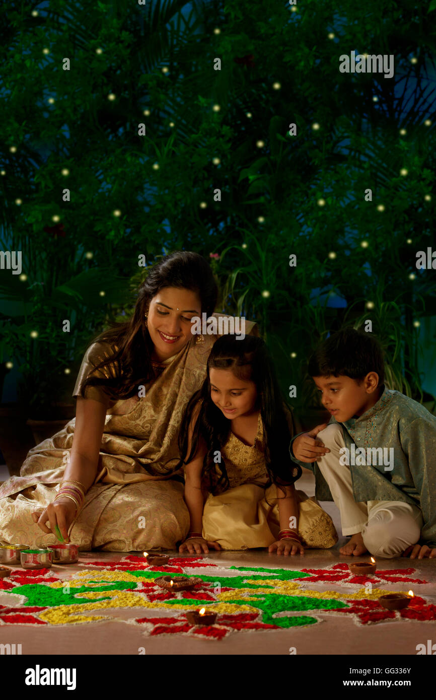 Woman making a rangoli with her kids Stock Photo - Alamy