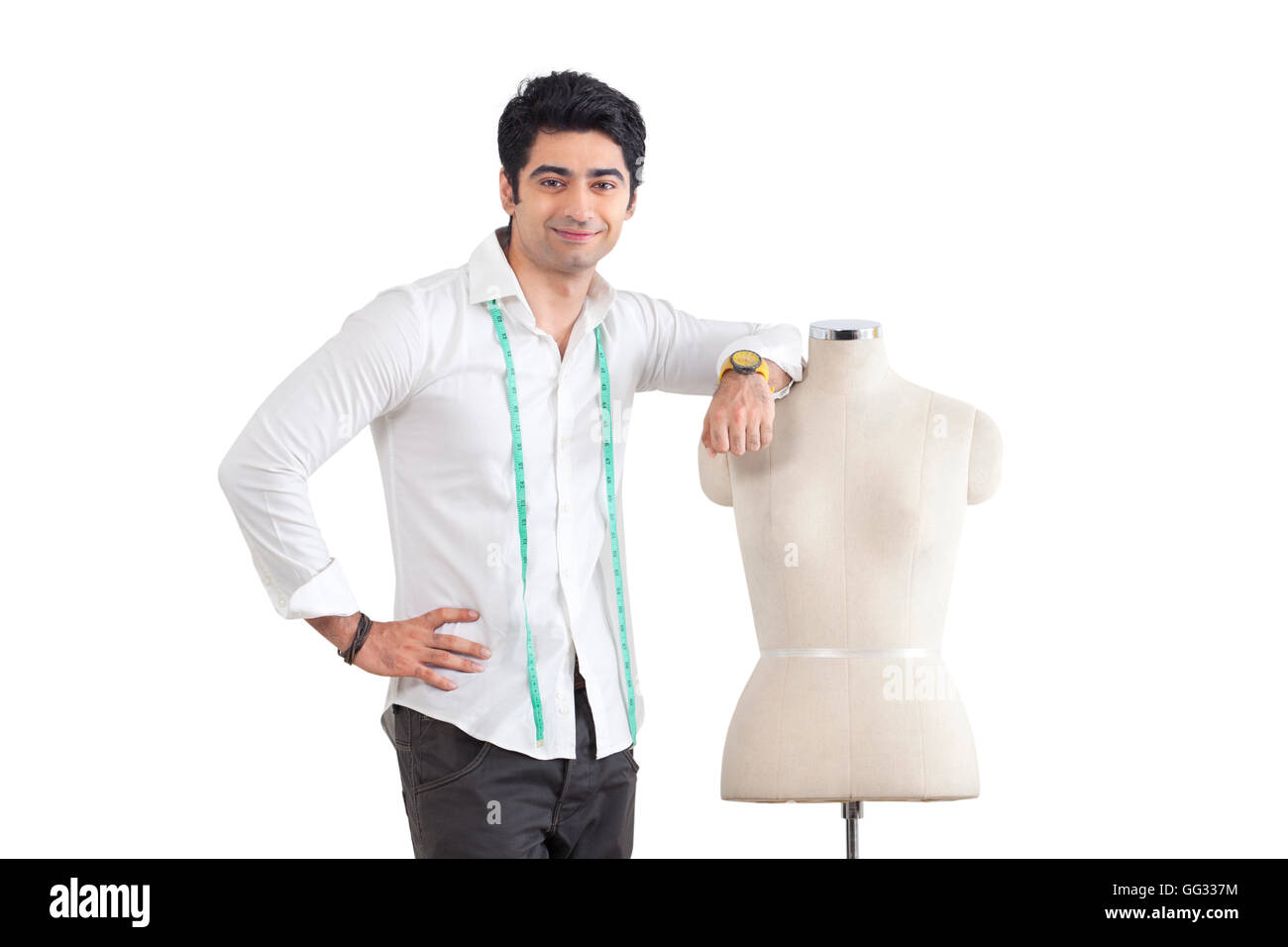 Young male fashion designer standing by mannequin over white background ...