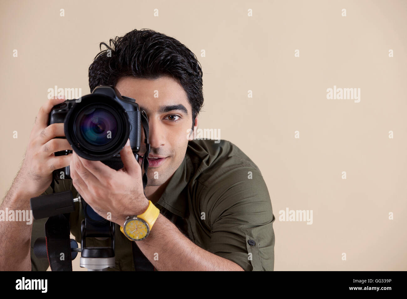 Close-up of young handsome photographer taking a photograph Stock Photo ...