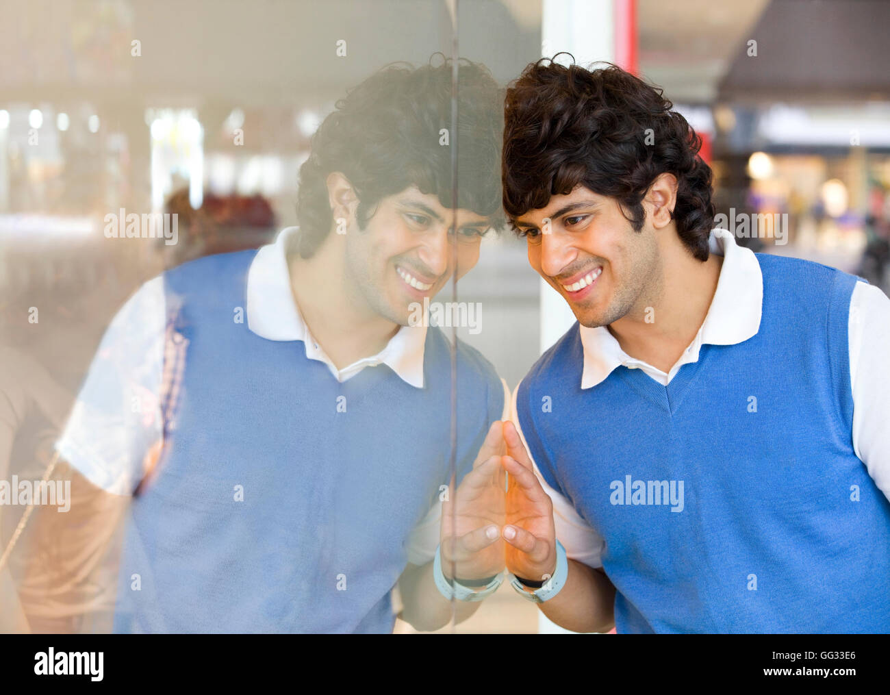 Young man looking at his reflection Stock Photo - Alamy