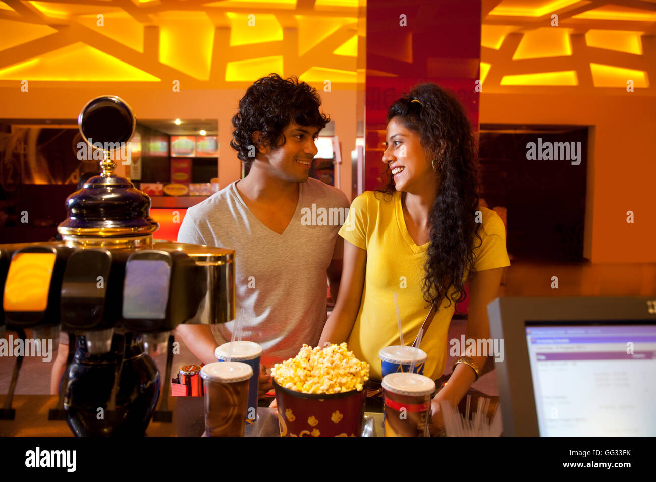 Young couple buying popcorn together at cinema lobby Stock Photo - Alamy