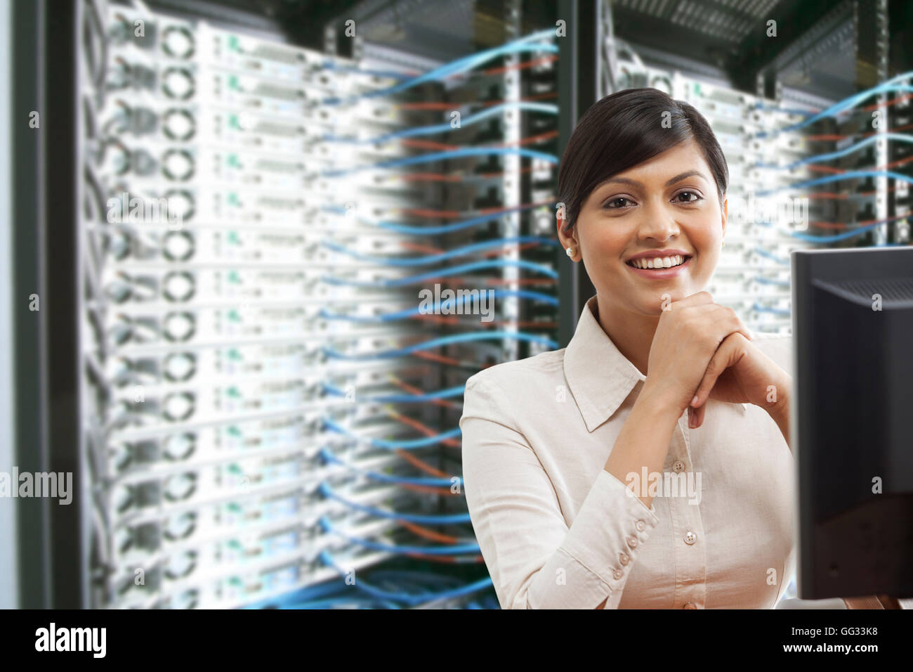 Portrait of smiling business woman sitting in server room Stock Photo ...