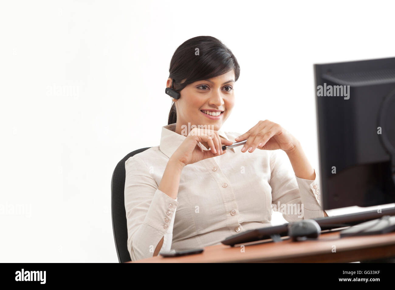 Female professional smiling while looking at computer Stock Photo - Alamy