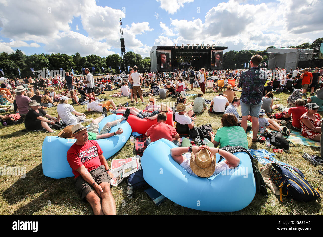 Festival goers relax on inflatable loungers in the main area in front ...