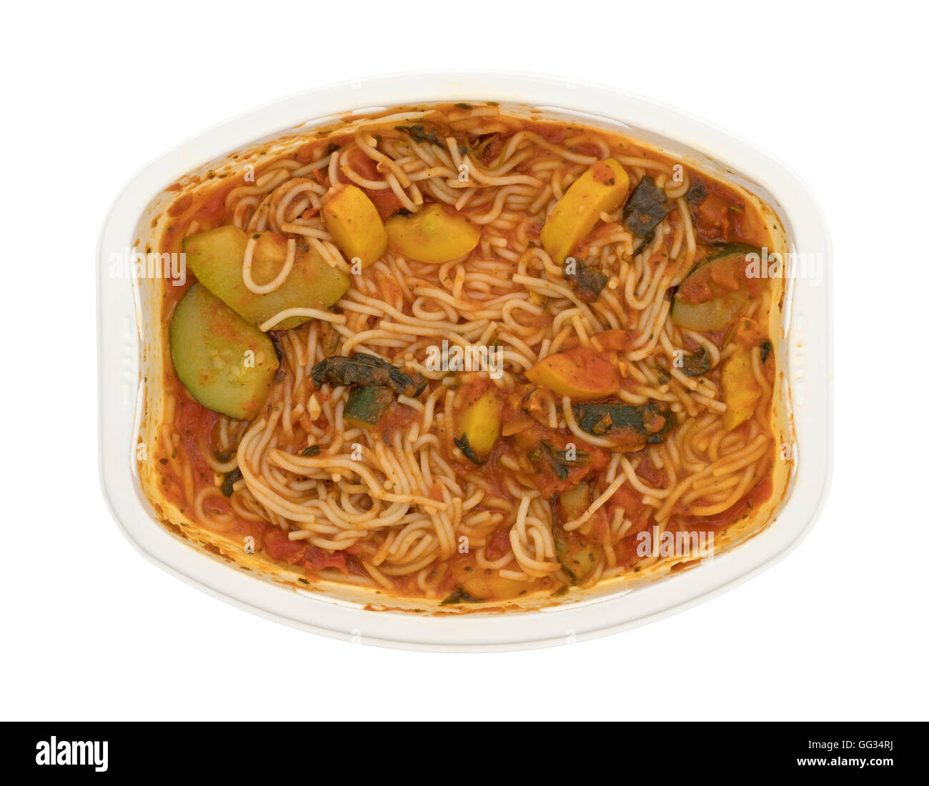 A cooked TV dinner of angel hair pasta with zucchini and spinach in a ...