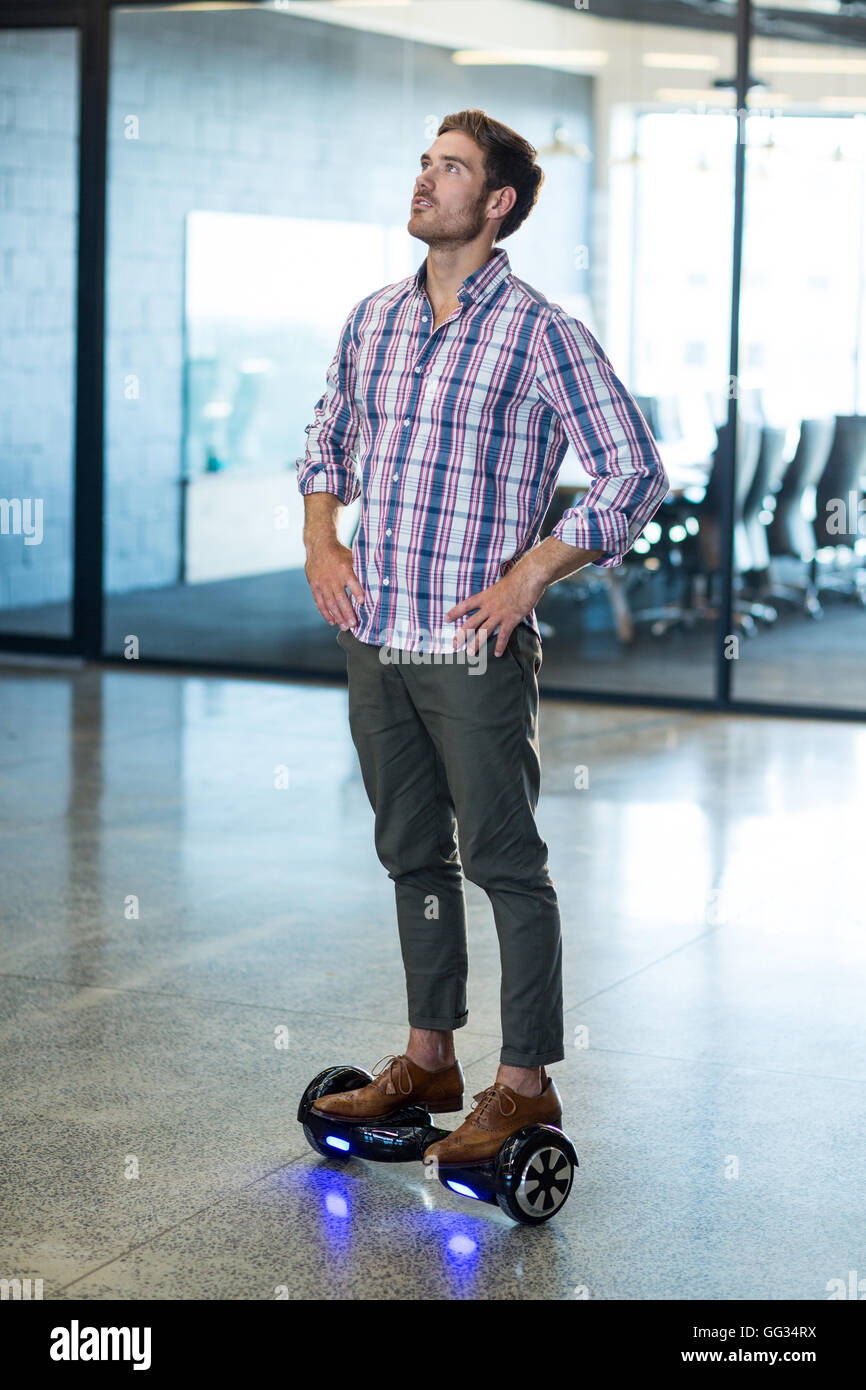 Graphic designer standing on hoverboard in office Stock Photo - Alamy