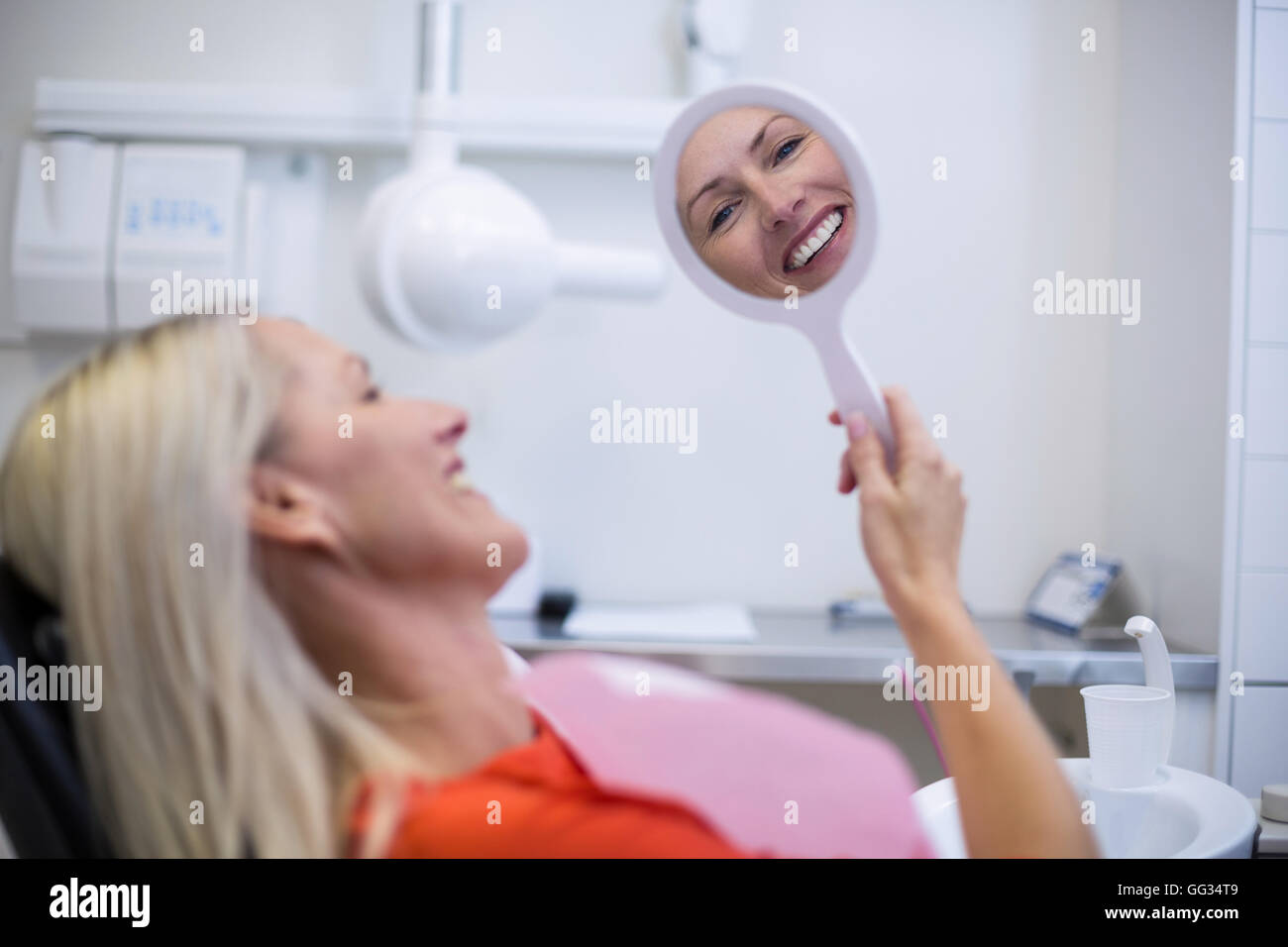 Patient checking her teeth in mirror Stock Photo - Alamy