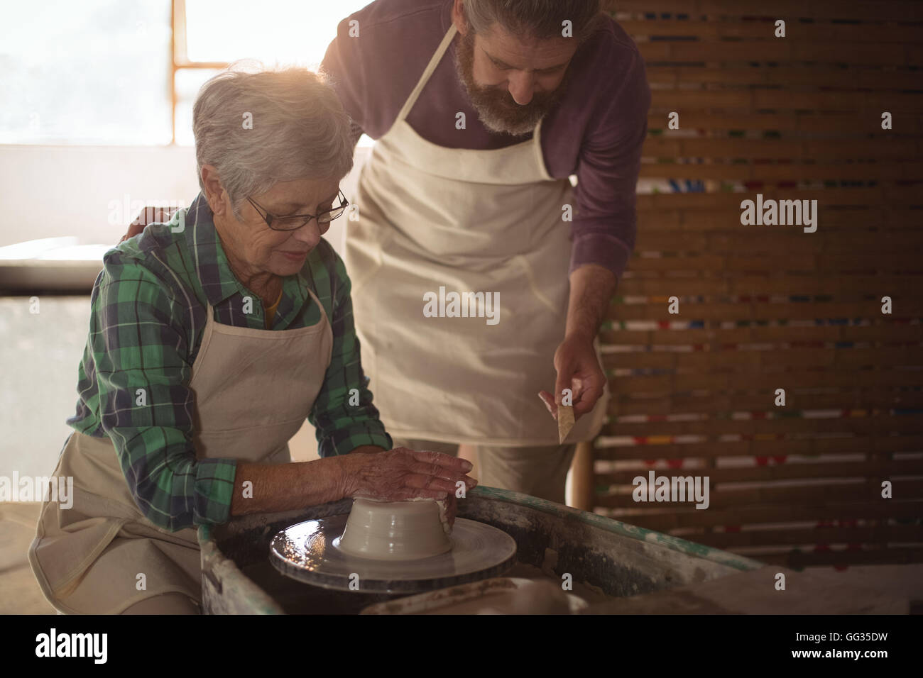 Male potter assisting female potter Stock Photo - Alamy