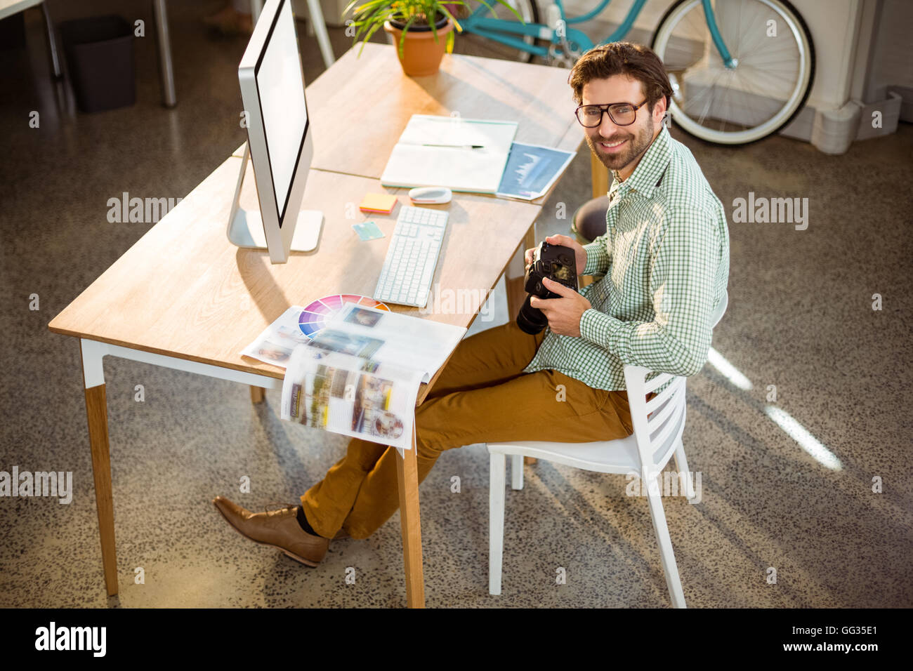 Graphic designer looking at pictures in digital camera Stock Photo - Alamy