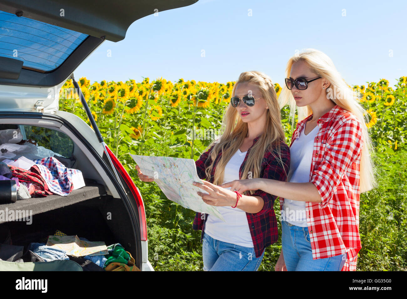 Two girls looking road map standing sunflowers field outdoor Stock ...