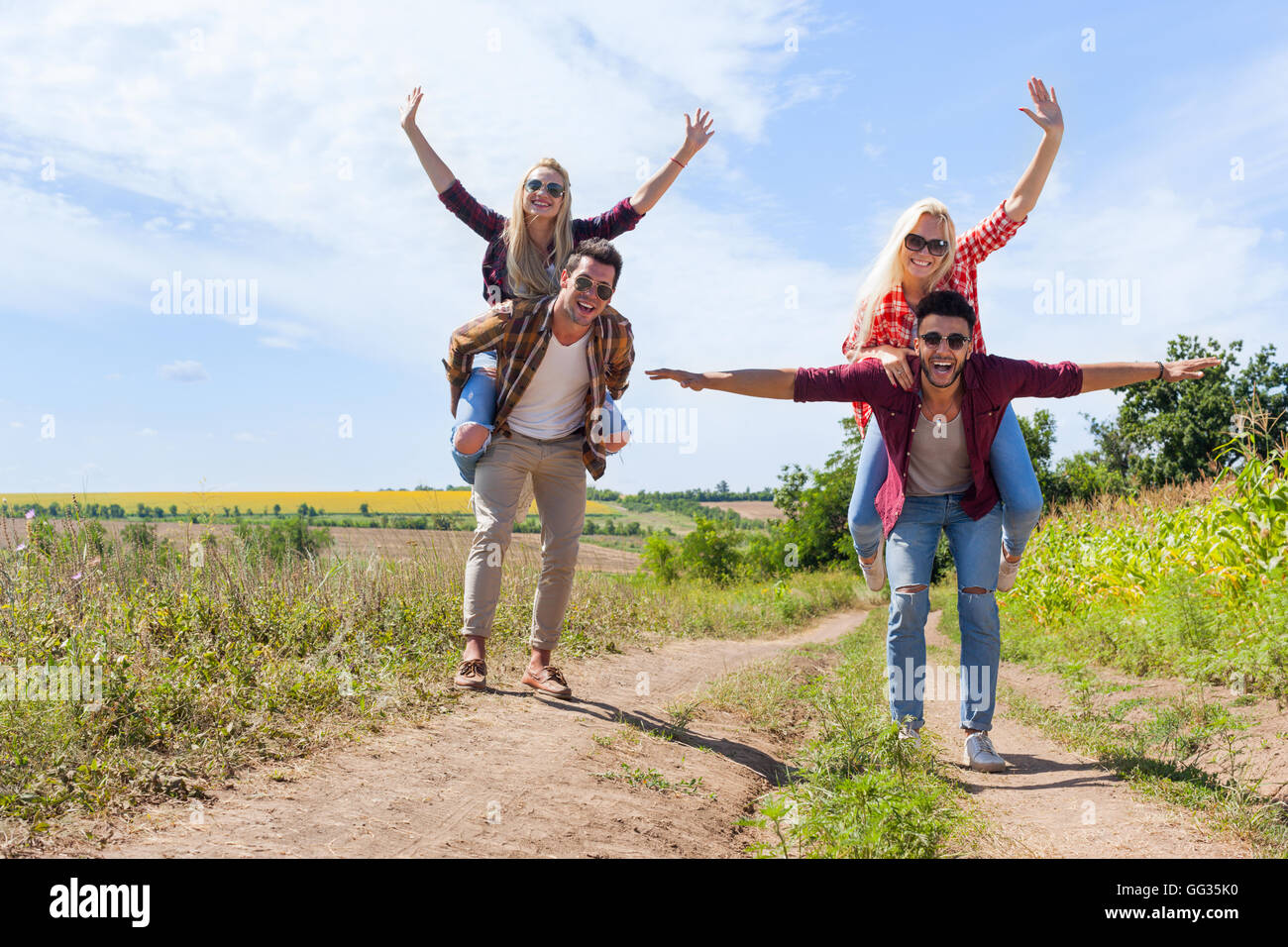 Two men girlfriends piggyback rides cheerful couple young friends Stock ...