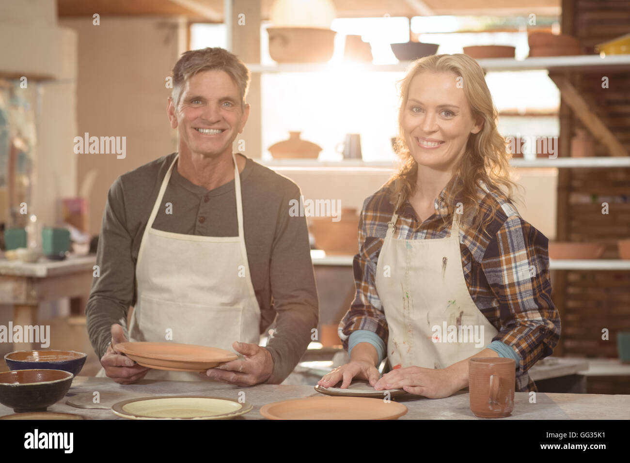 Smiling potters working together in pottery workshop Stock Photo - Alamy