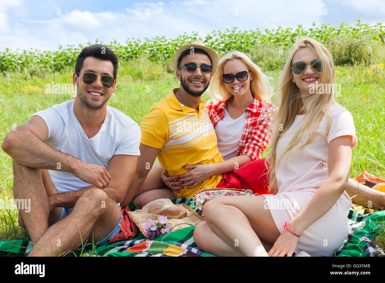 Friends picnic people group sitting blanket outdoor green grass Stock ...